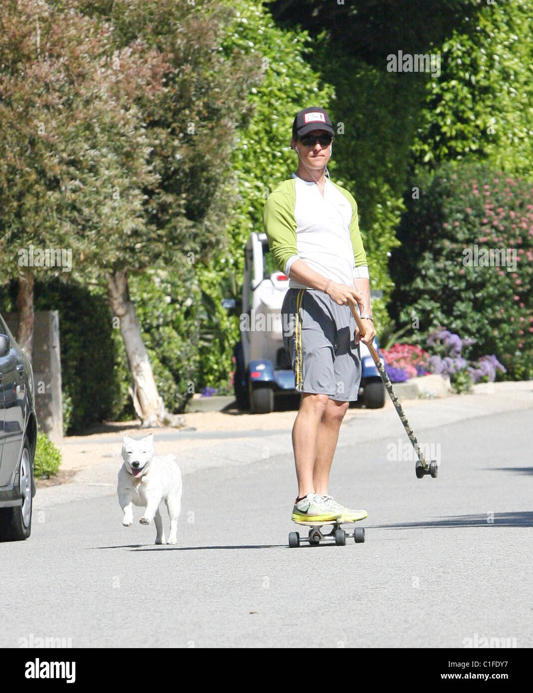 Matthew McConaughey rides on a skateboard followed by his dog Malibu ...