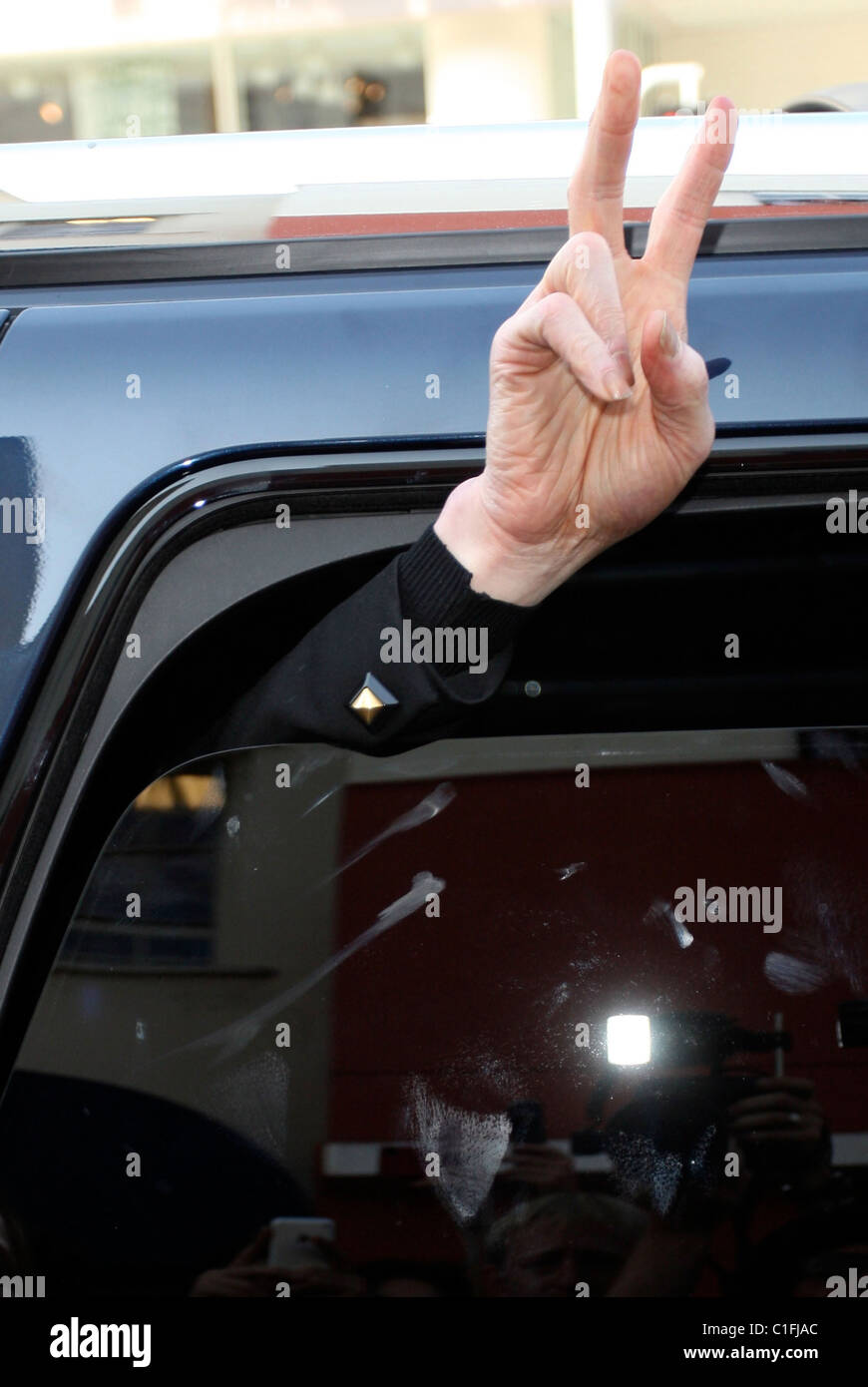 Michael Jackson makes a peace sign from his car as he leaves Tom's Toys ...