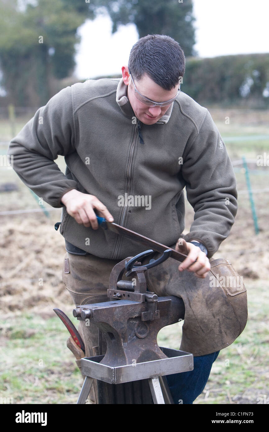 Farrier filing new horseshoe prior to fitting Stock Photo - Alamy