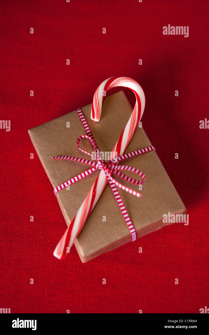 Candy can on top of Christmas gift Stock Photo - Alamy