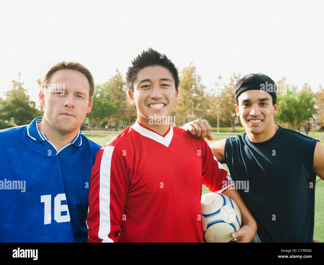 Smiling soccer players with ball Stock Photo - Alamy