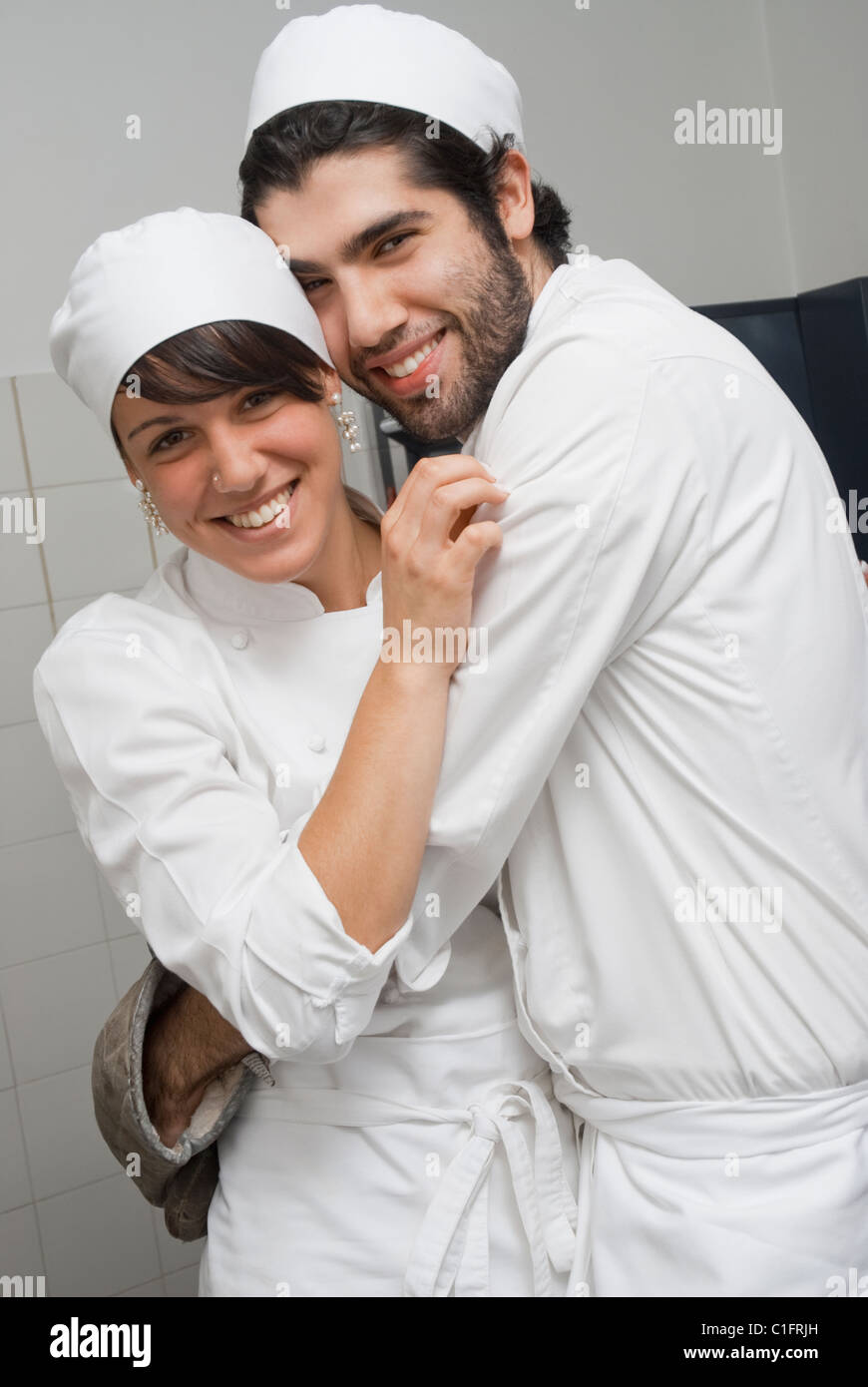 Bakers hugging in bakery kitchen Stock Photo - Alamy