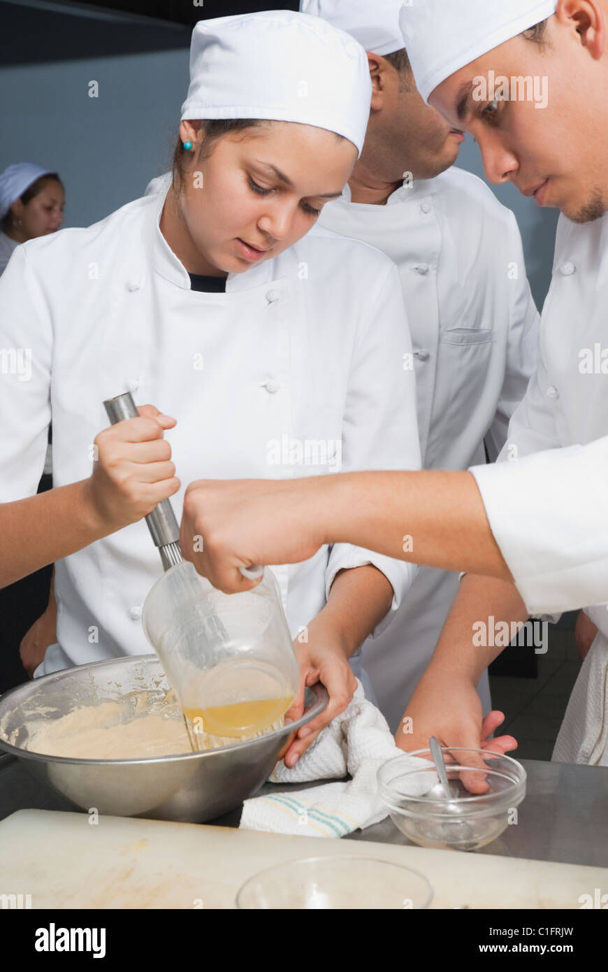 Bakers stirring batter in bakery kitchen Stock Photo - Alamy