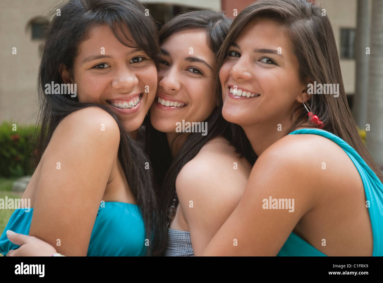 Smiling Hispanic friends hugging Stock Photo - Alamy