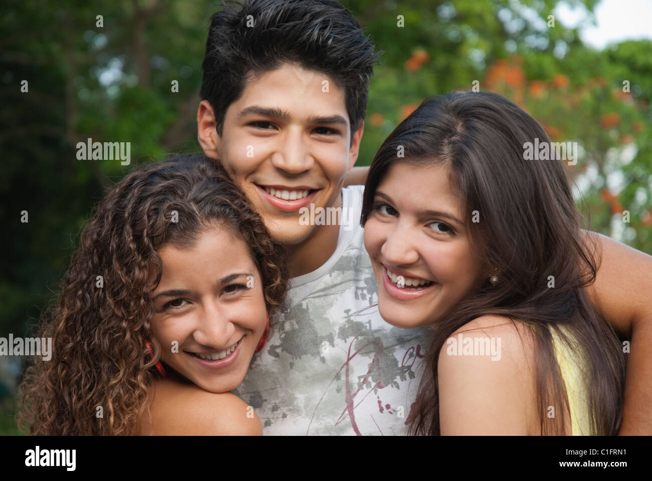 Hispanic friends hugging Stock Photo - Alamy