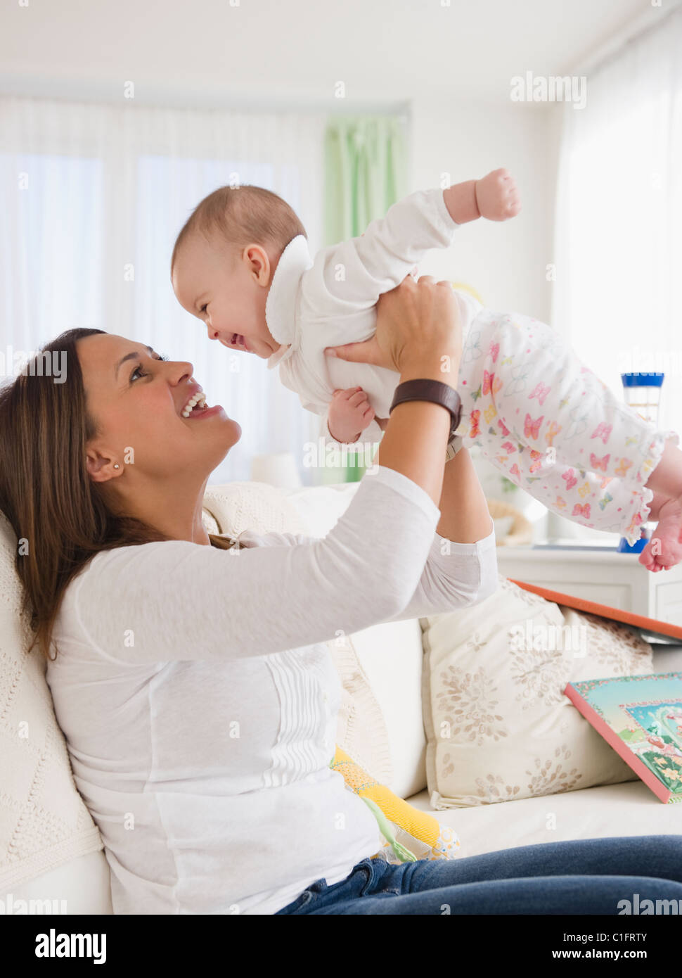 Smiling mother lifting baby Stock Photo - Alamy