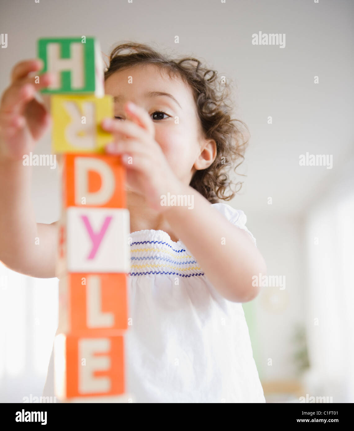 Mixed race girl stacking blocks Stock Photo - Alamy