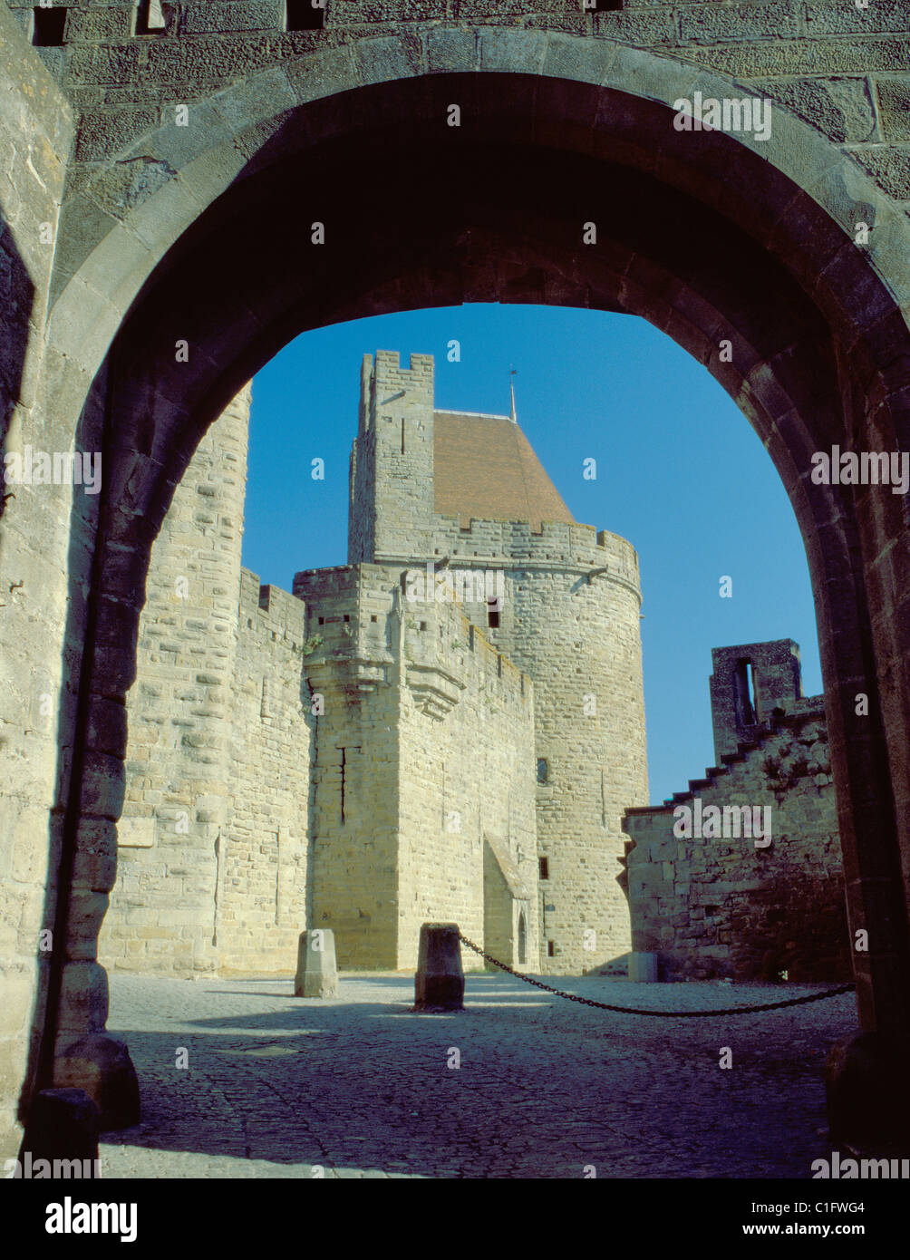 Stone tower and walls seen through an archway, walled cité of ...