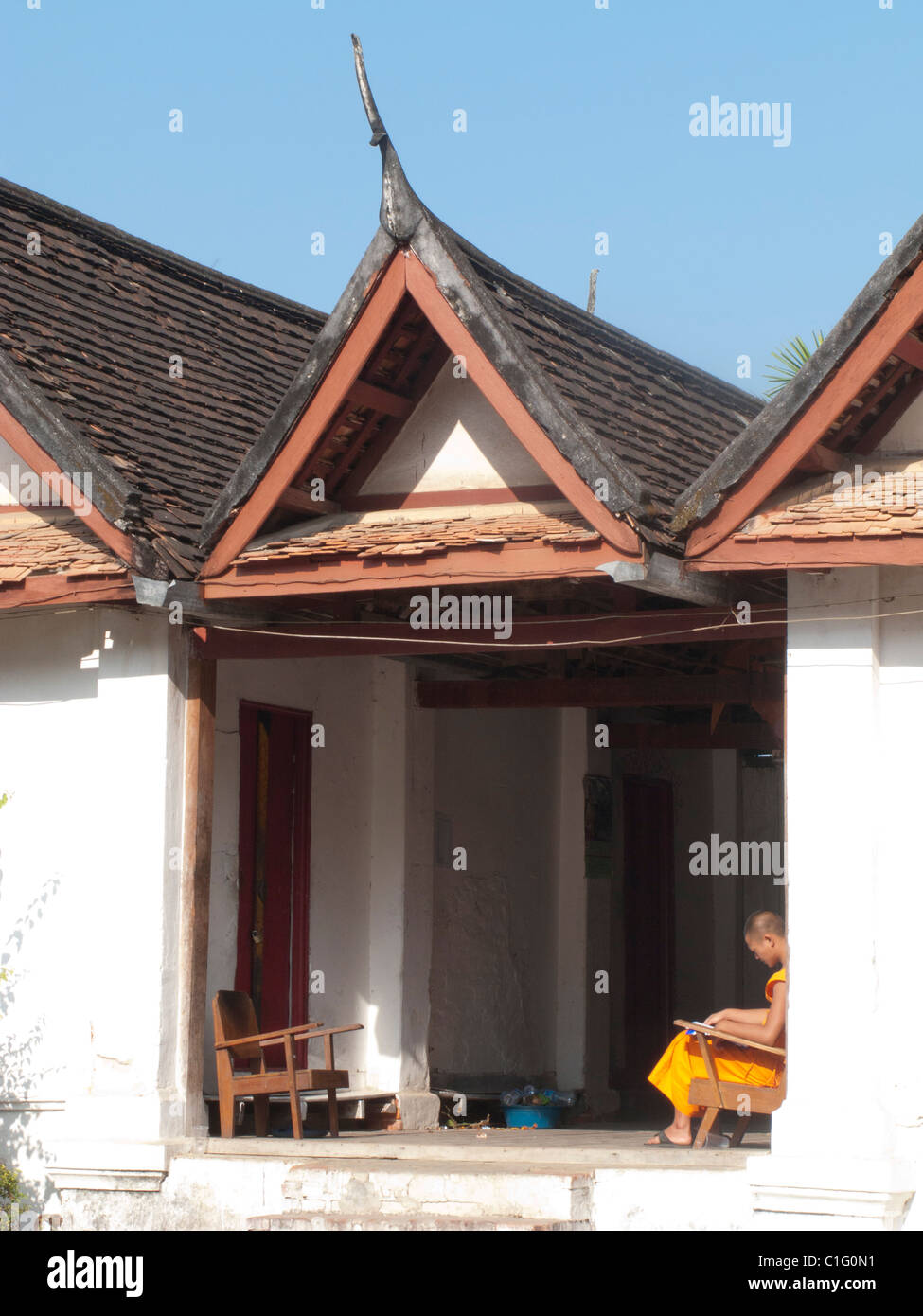 LAOS.MONK READING IN A MONASTERY IN THE HOLY CITY OF LUANG PRABANG ...