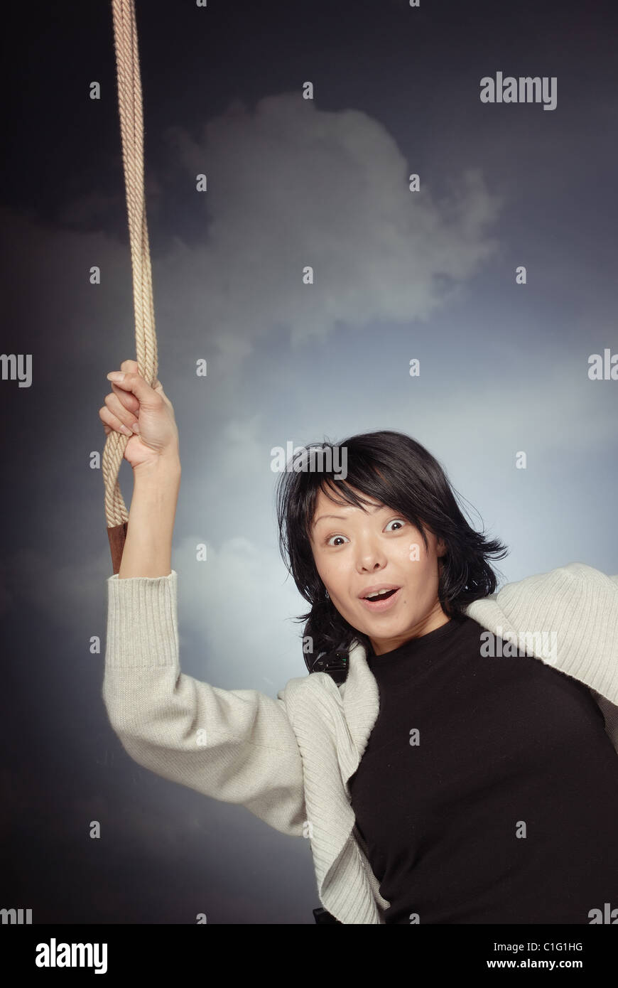 Funny lady falling and holding the rope on a sky background Stock Photo ...