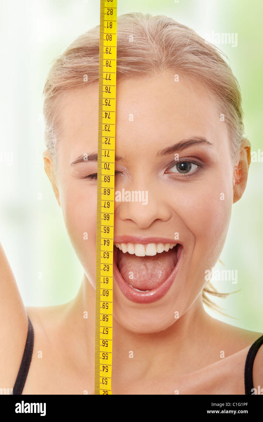 Beautiful young caucasian woman measuring her body with tape Stock ...