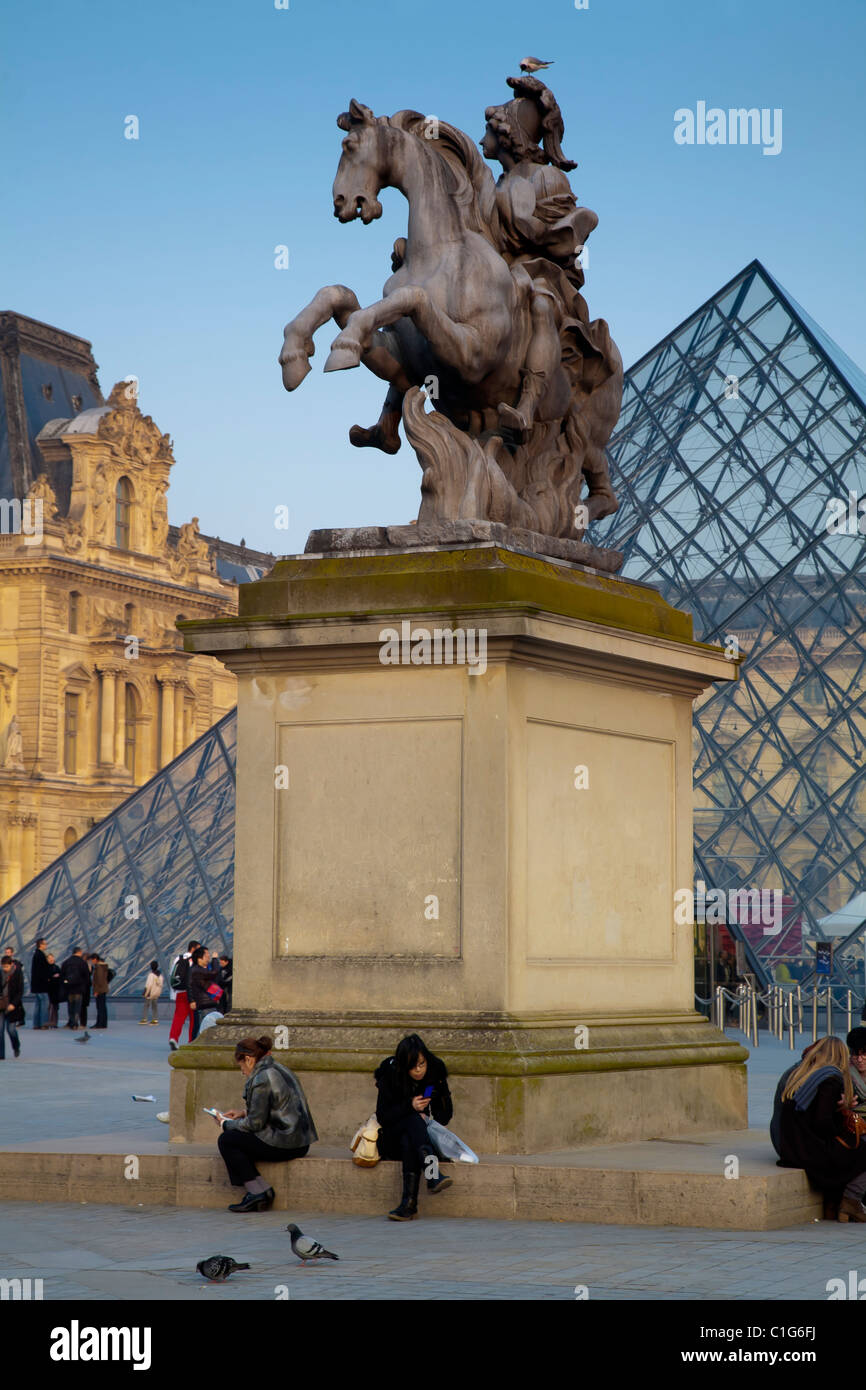 Louis XIV statue (Sun King) and Crystal Pyramid in front of the Louvre ...