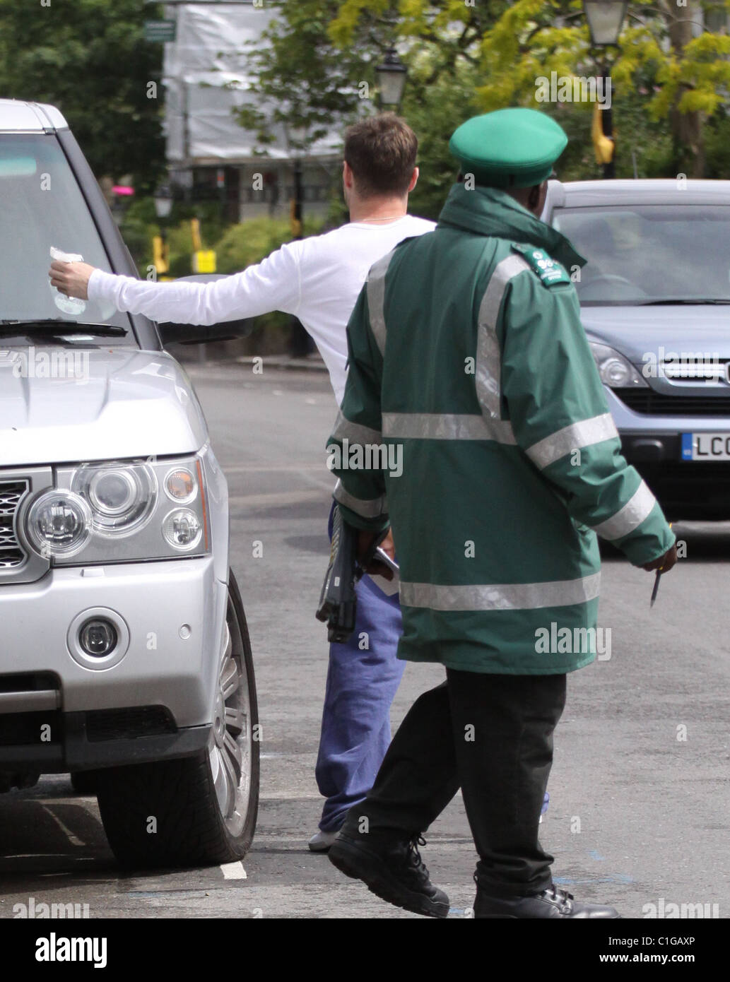 DJ Tom Crane emerges from his house to remove a parking ticket from his ...