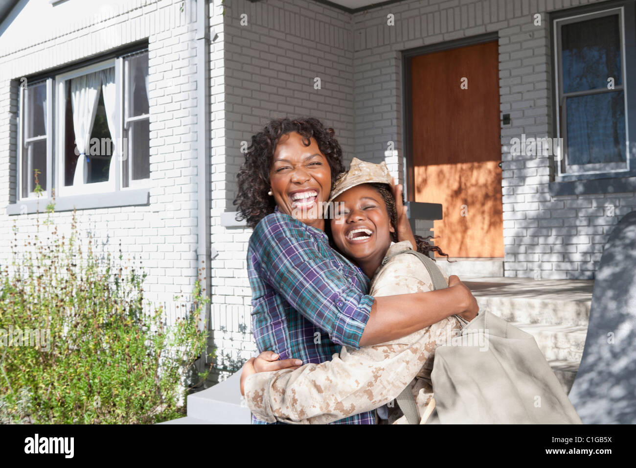 Black mother hugging soldier daughter Stock Photo - Alamy