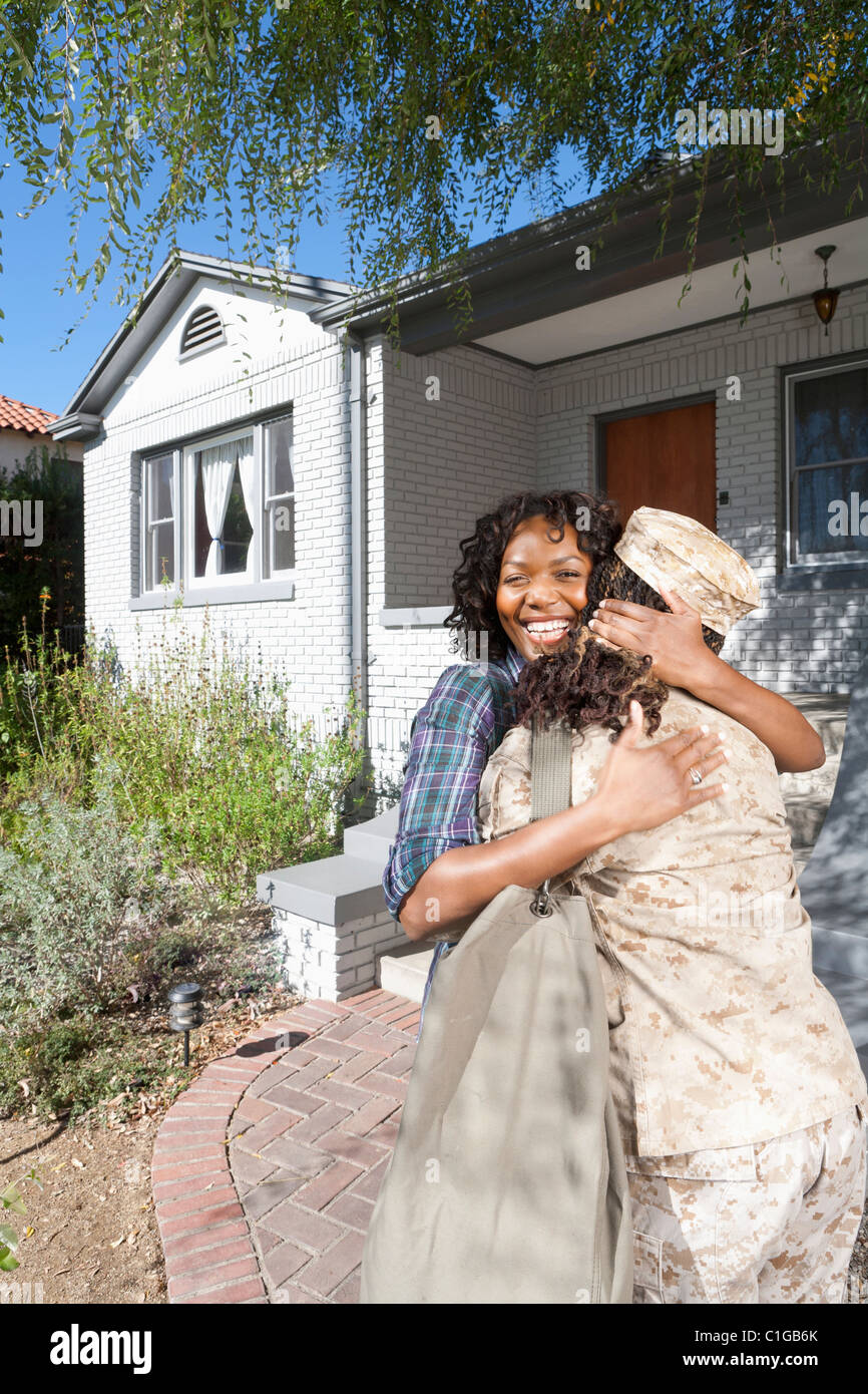 Black mother hugging soldier daughter Stock Photo - Alamy