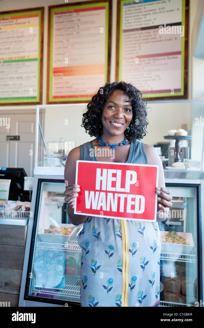 Black woman holding help wanted sign in bakery Stock Photo - Alamy