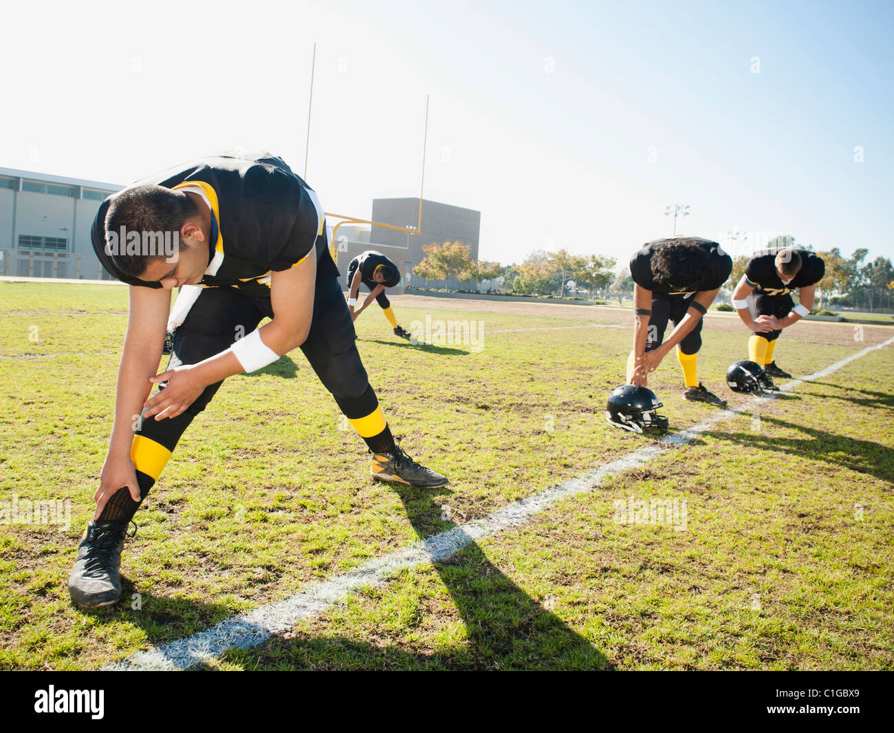 Football players stretching on football field Stock Photo - Alamy