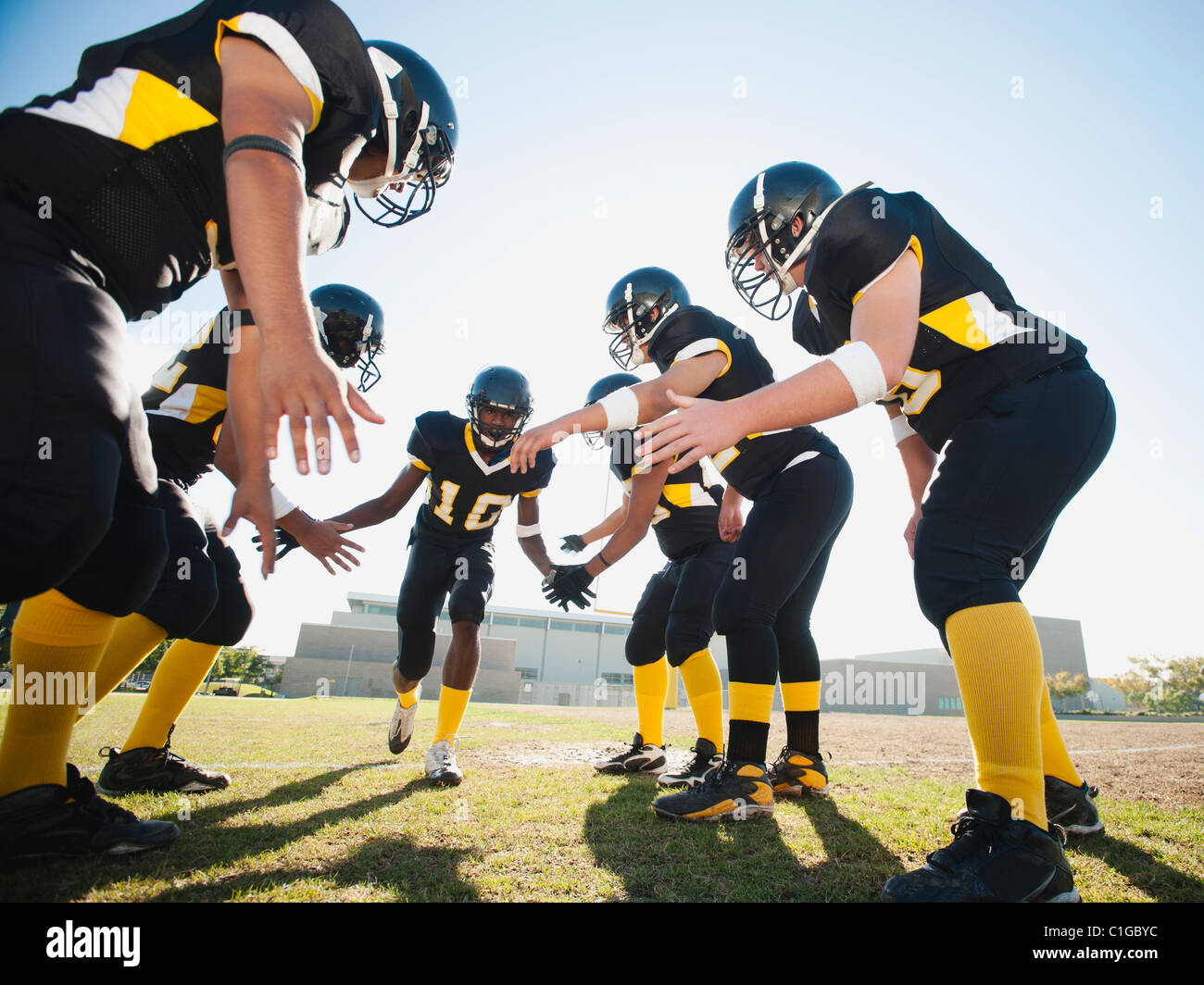 Football players crouching on football field Stock Photo - Alamy