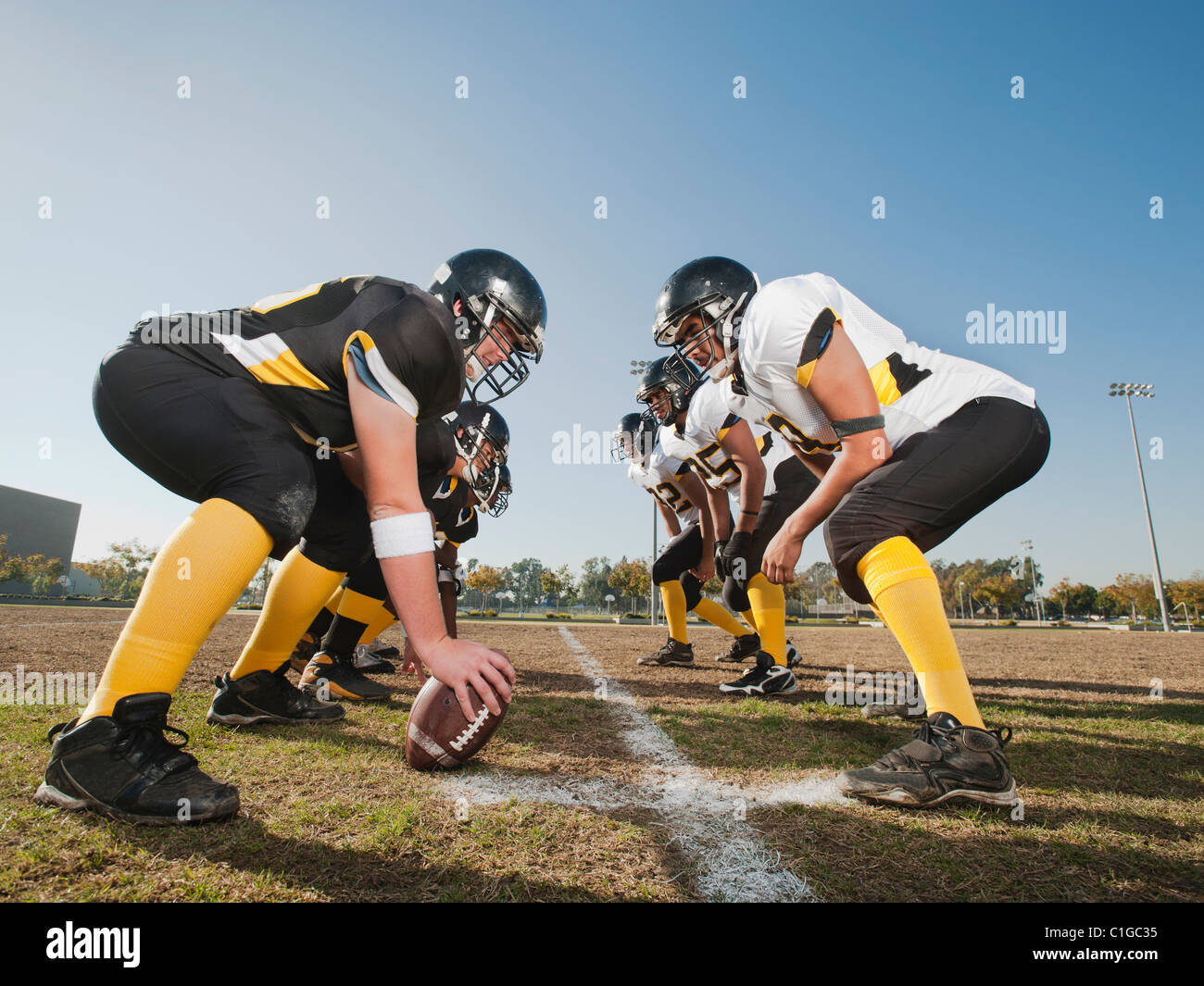 Football players crouching on football field Stock Photo - Alamy