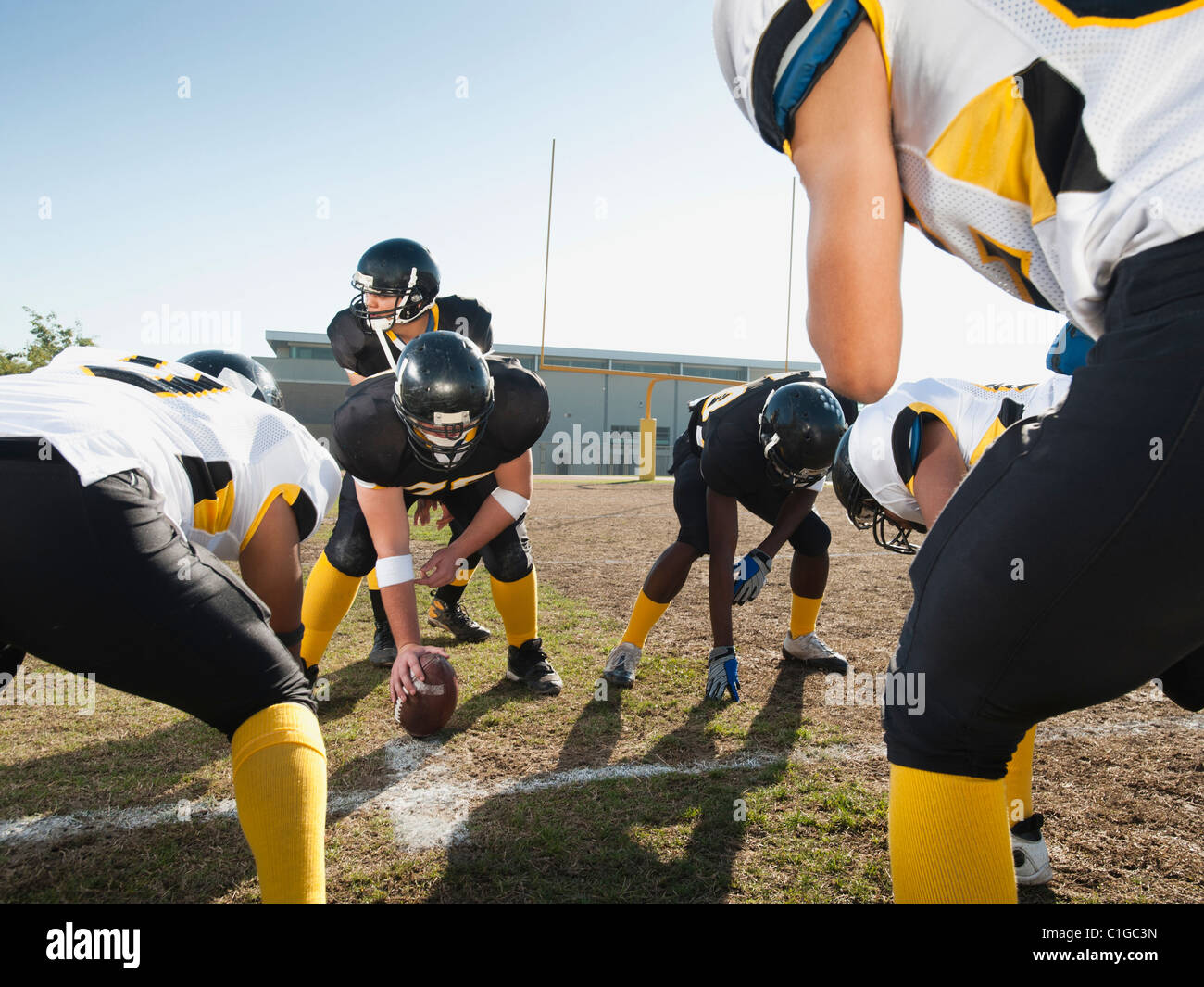 Football players crouching on football field Stock Photo - Alamy