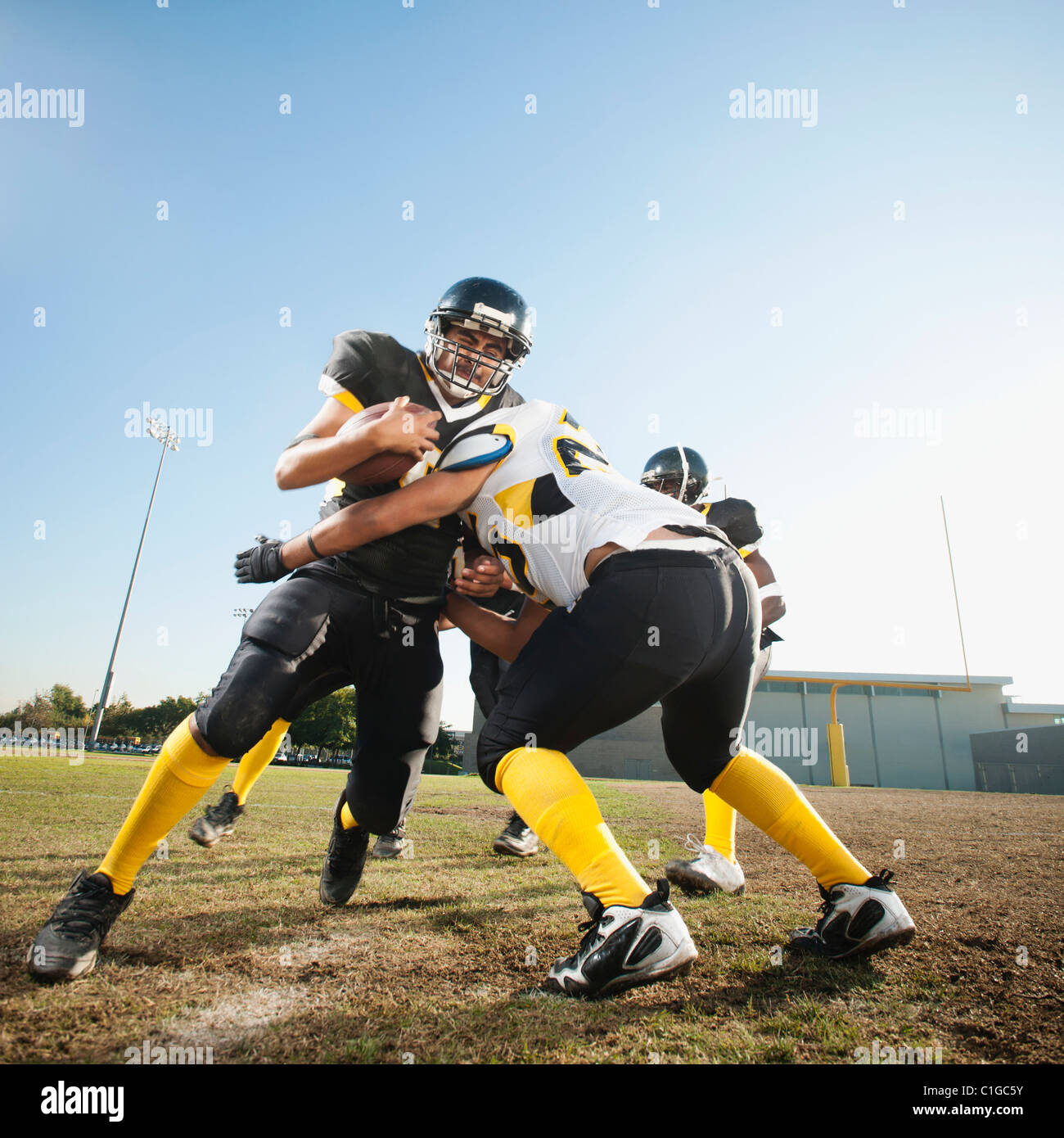 Football player tackling player on football field Stock Photo - Alamy