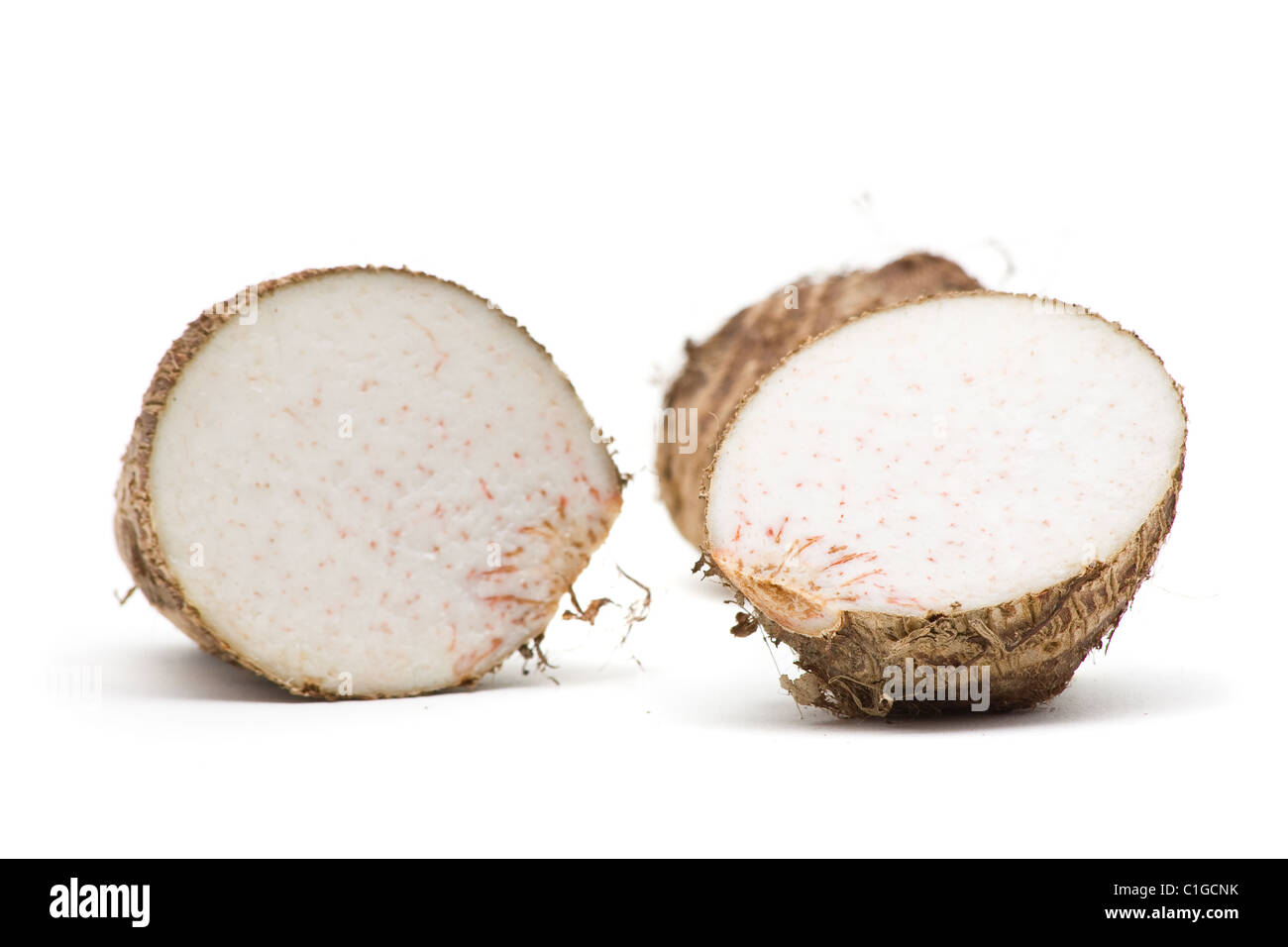 Fresh taro root cut in half over white background Stock Photo - Alamy