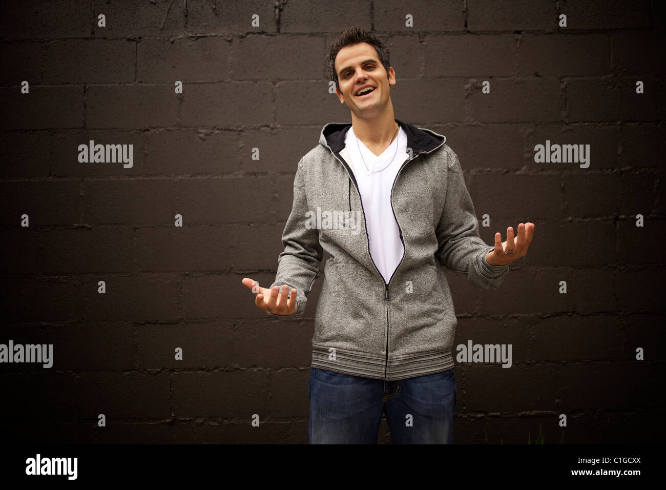 Smiling Caucasian man shrugging Stock Photo - Alamy