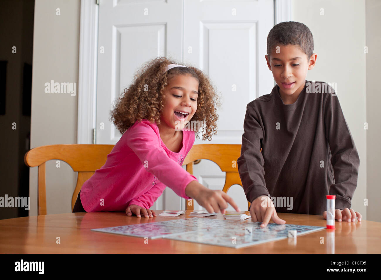 Mixed race children playing board game together Stock Photo - Alamy