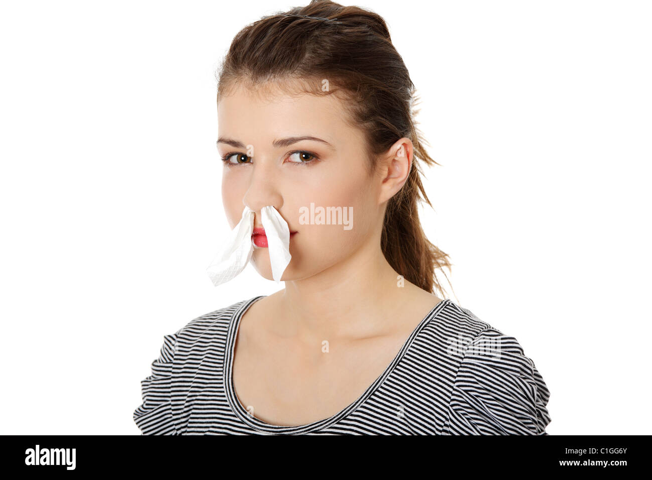 Teen woman with tissue in her nose, isolated on white background Stock ...