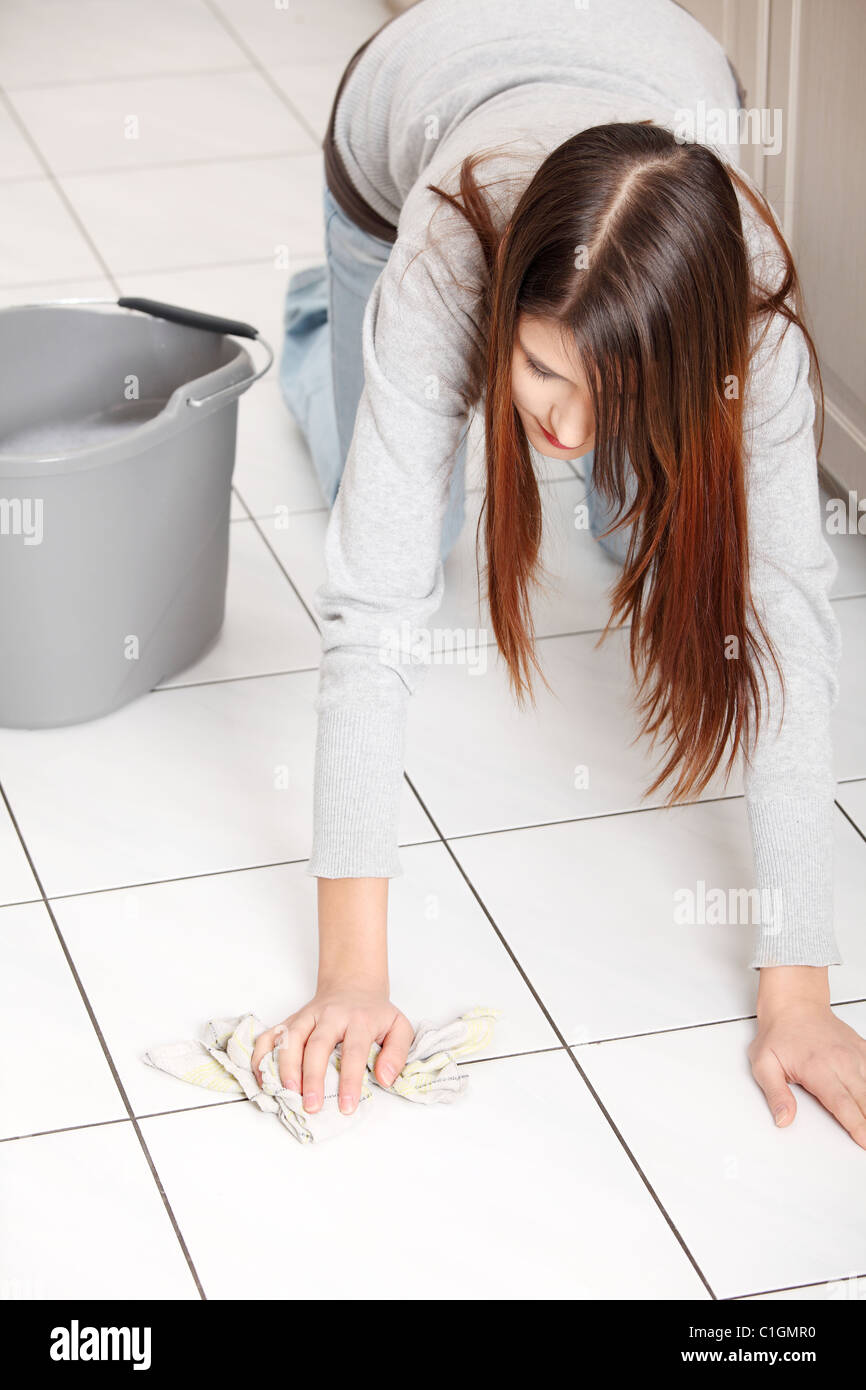 Young woman cleaning floor on her knees Stock Photo - Alamy