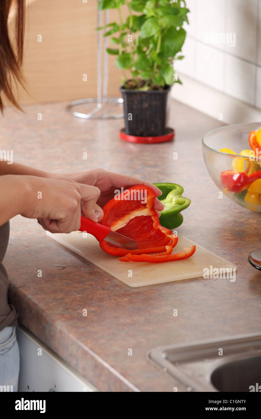 Female chopping food ingredients (paprika) on the kitchen Stock Photo ...