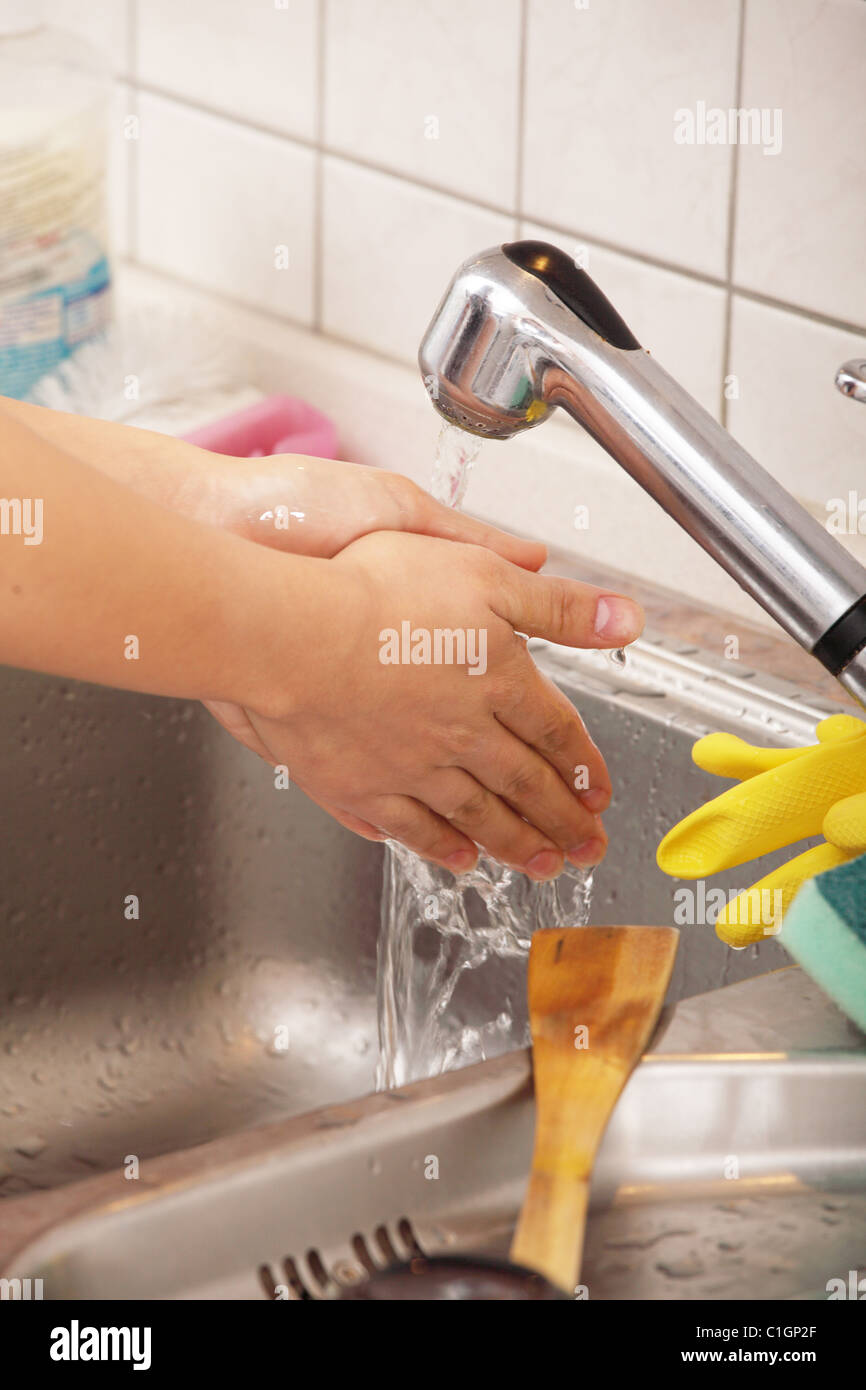 Woman washing her hands in kitchen Stock Photo - Alamy