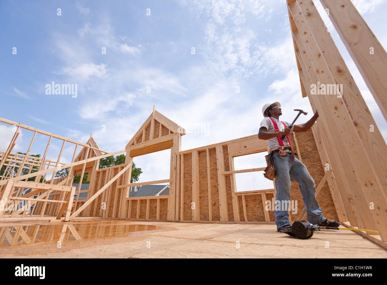 Hispanic carpenter working on the upper floor of a house under ...