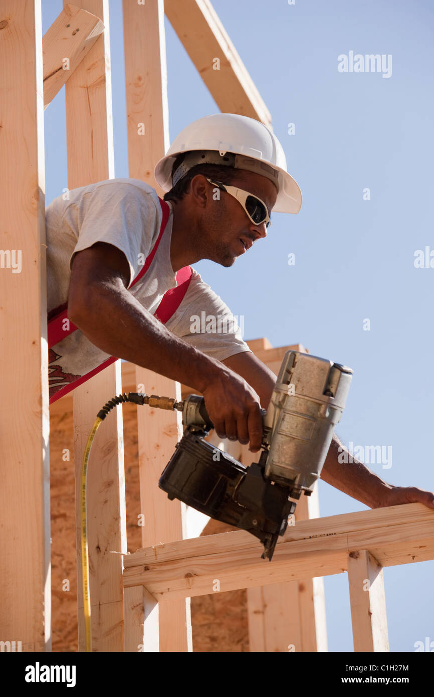 Hispanic carpenter using a nail gun on a window frame Stock Photo - Alamy