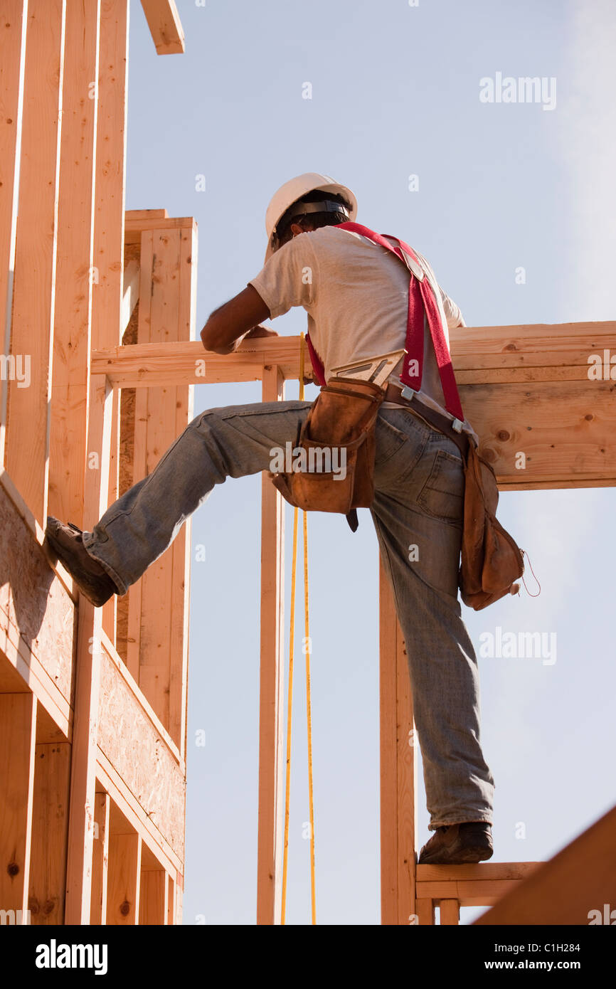 Hispanic carpenter working on the upper floor of a house under ...