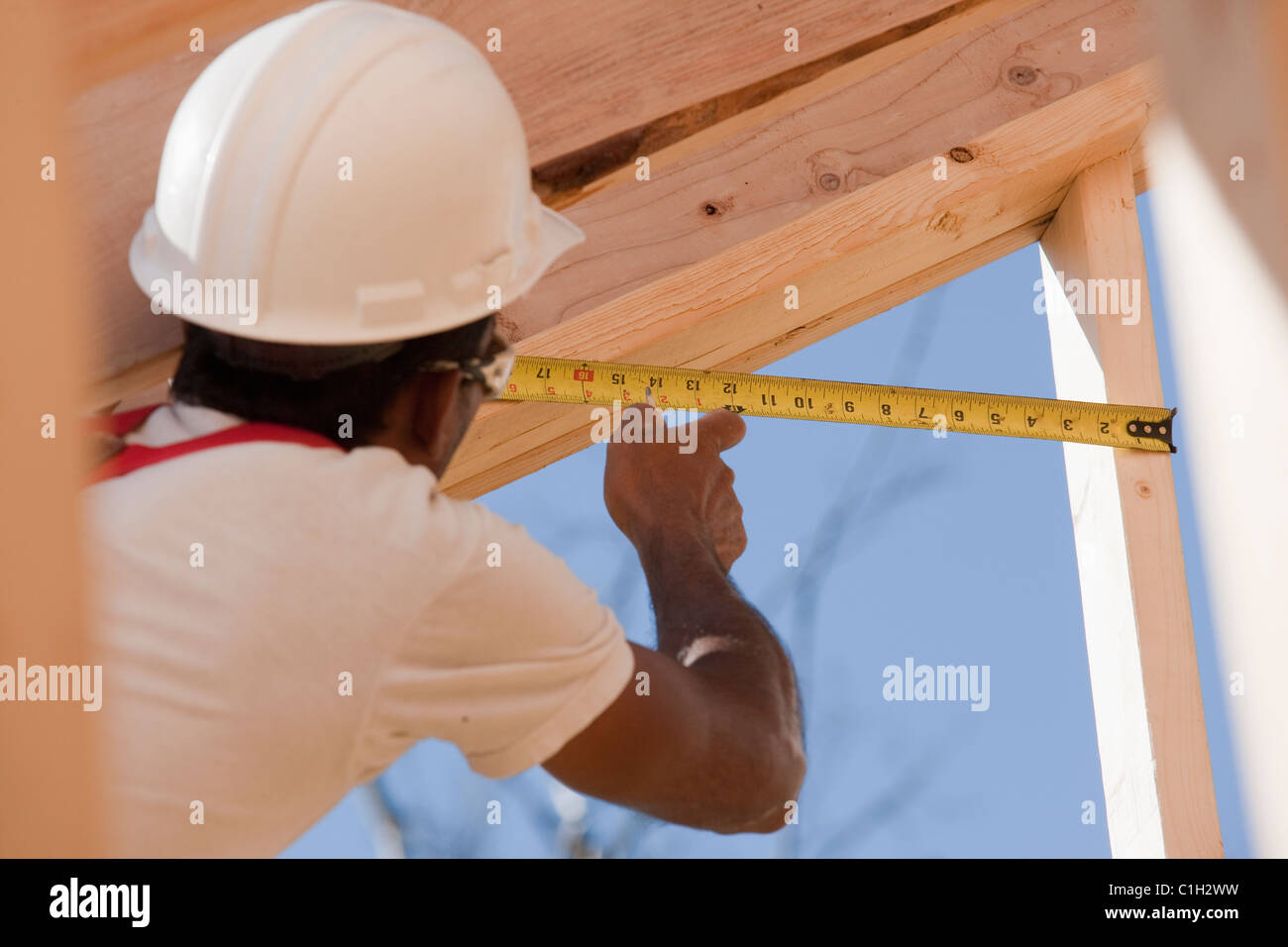 Carpenter measuring a wooden beam Stock Photo - Alamy