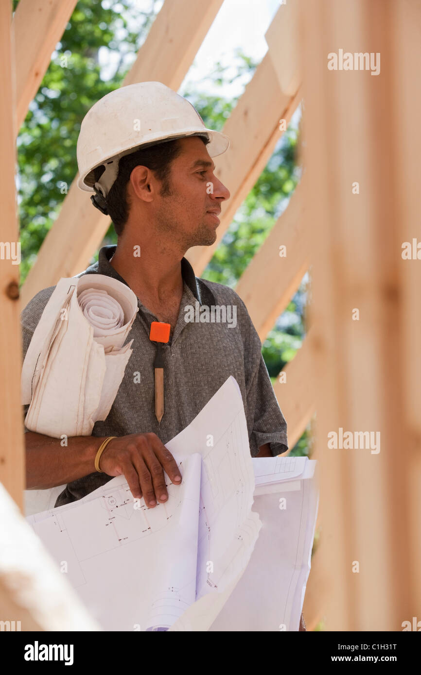 Carpenter holding blueprints of house Stock Photo - Alamy