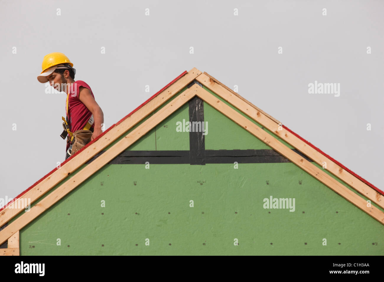 Hispanic carpenter working on the roof of a house under construction ...