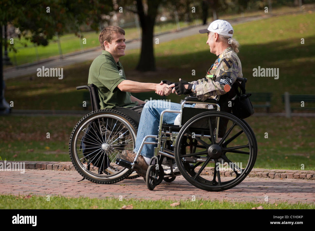 Two veterans shaking hands in wheelchairs Stock Photo - Alamy
