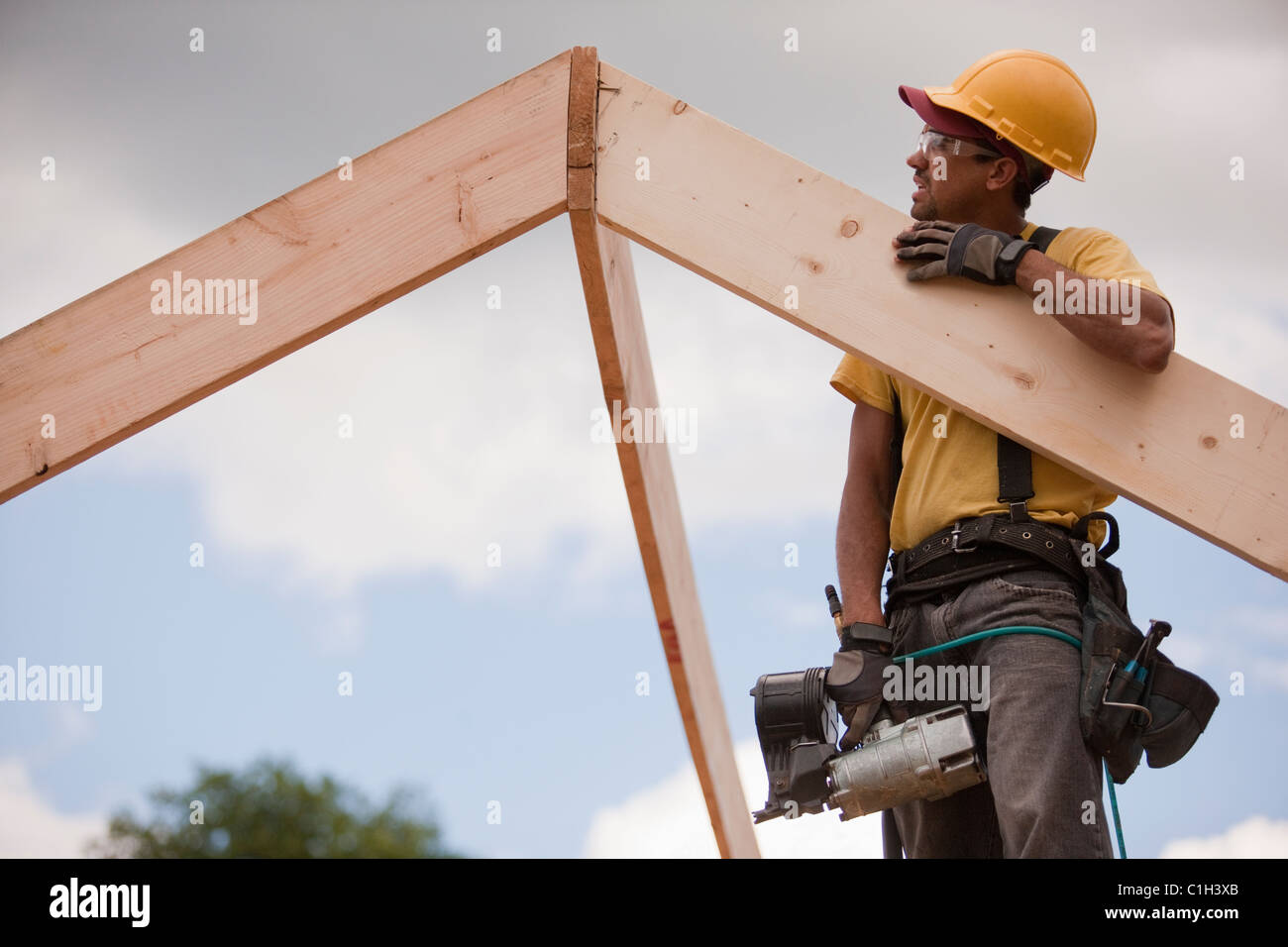 Low angle view of a carpenter nailing roof rafters Stock Photo - Alamy