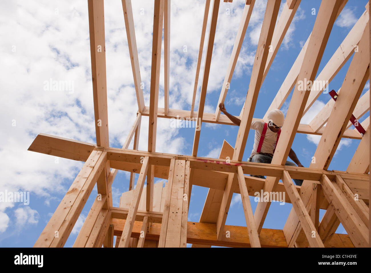Low angle view of a carpenter adjusting roof framing Stock Photo - Alamy
