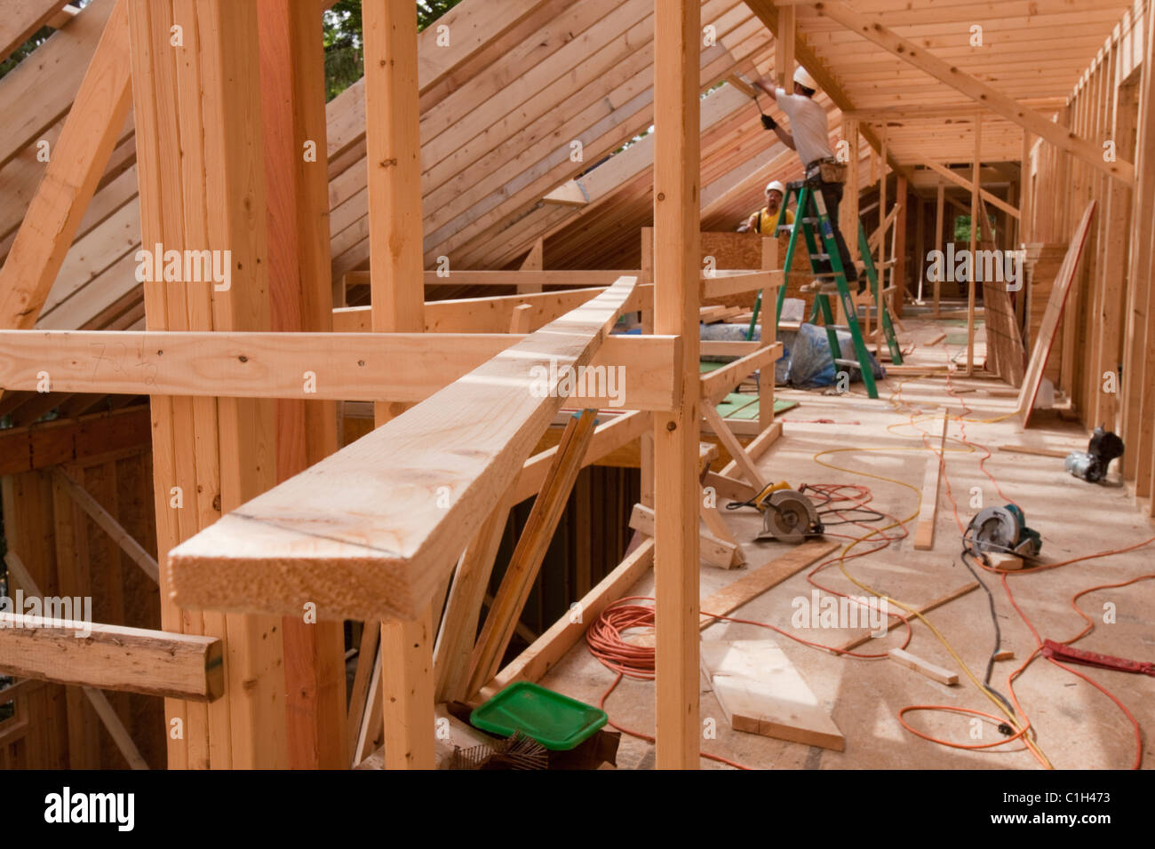 Hispanic carpenters installing window opening on roof at a house under ...