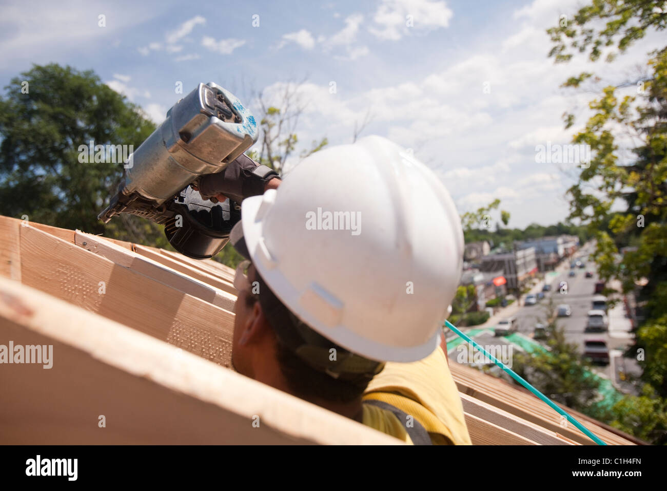 Hispanic carpenter using a nail gun at a house under construction Stock ...