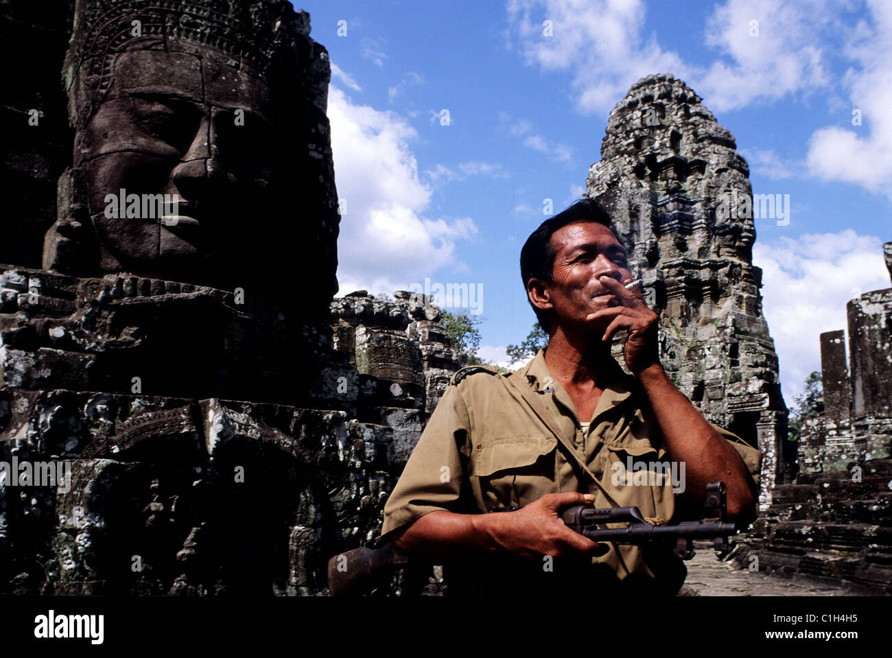 Cambodia, Angkor, soldier smoking a cigarette while he is taking care ...