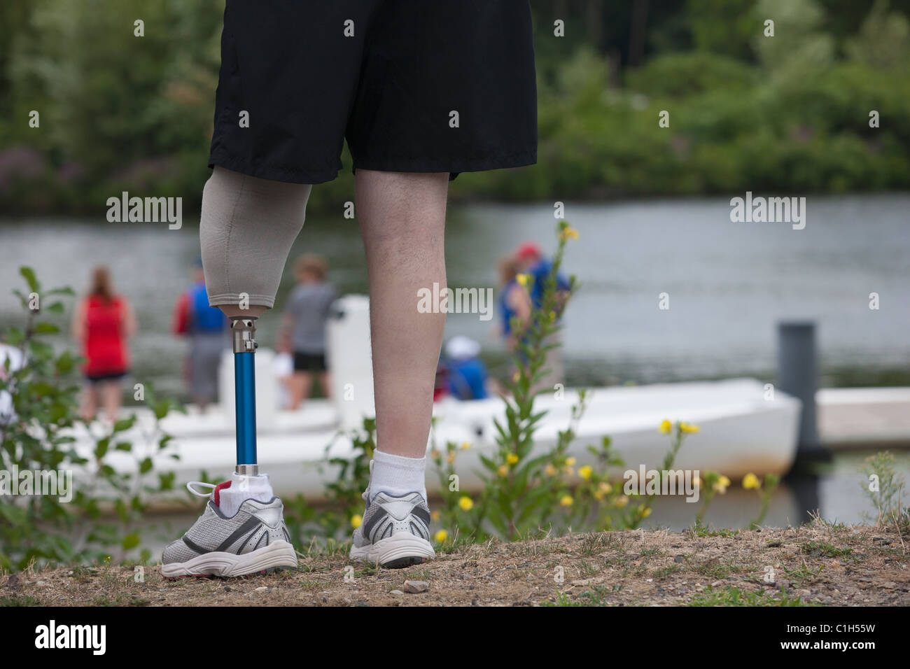 Man with a prosthetic leg standing on the dock and watching the boat ...