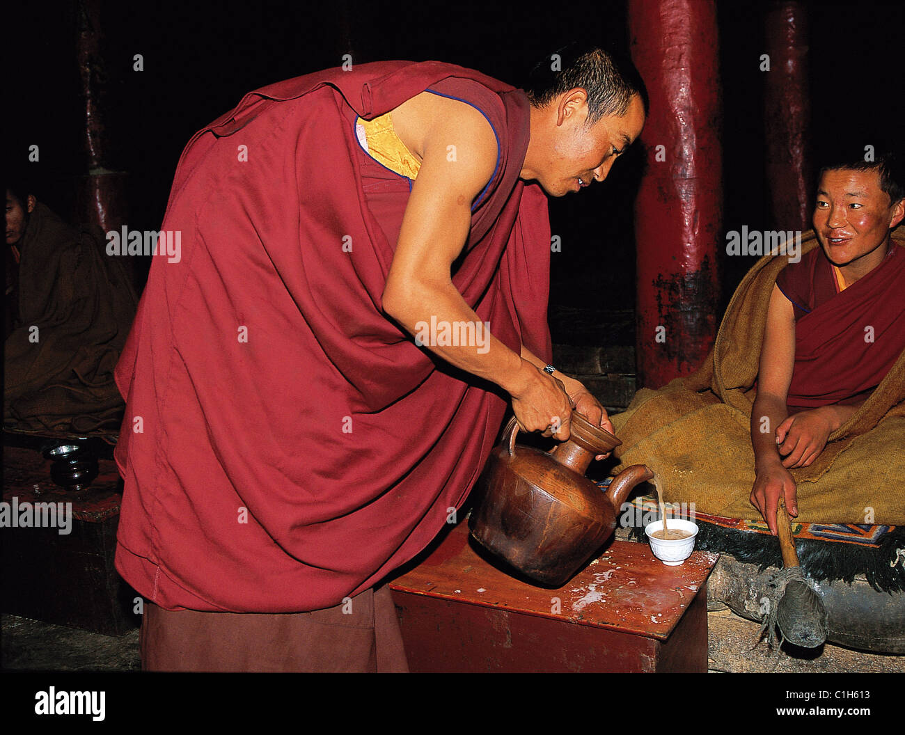 China, Central Tibet, monk serving tea in a monastery, ceremony being a ...