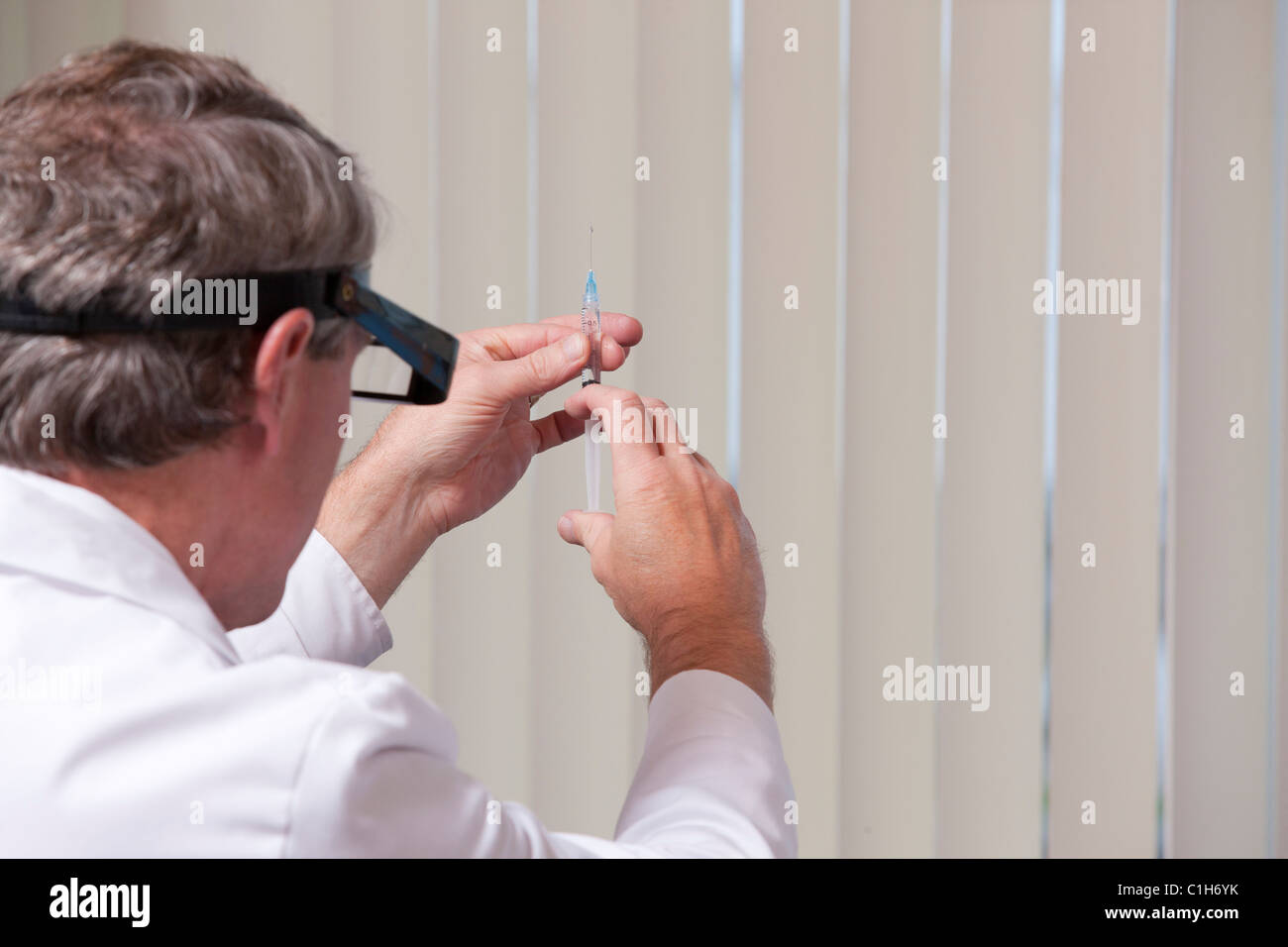 Doctor removing air from syringe Stock Photo - Alamy