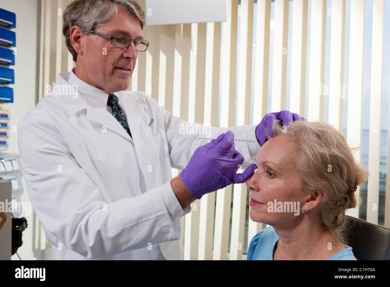 Ophthalmologist giving a Botox injection to a patient Stock Photo - Alamy