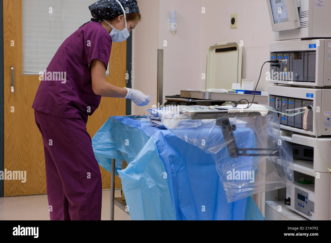Surgical technologist setting up back table of instruments prior to ...