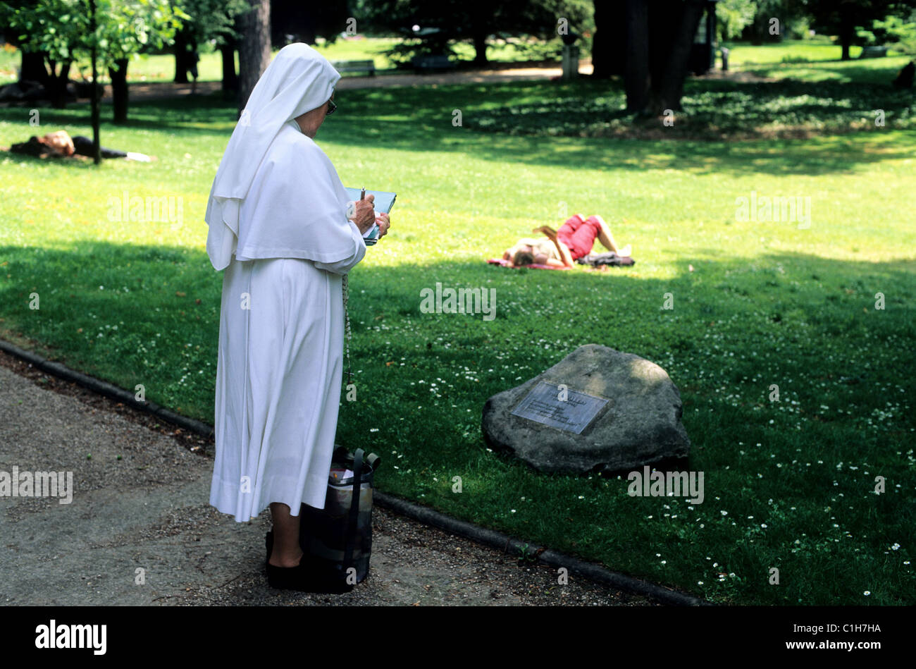 France, Paris, Poets garden, nun reading a poem on a stone Stock Photo ...